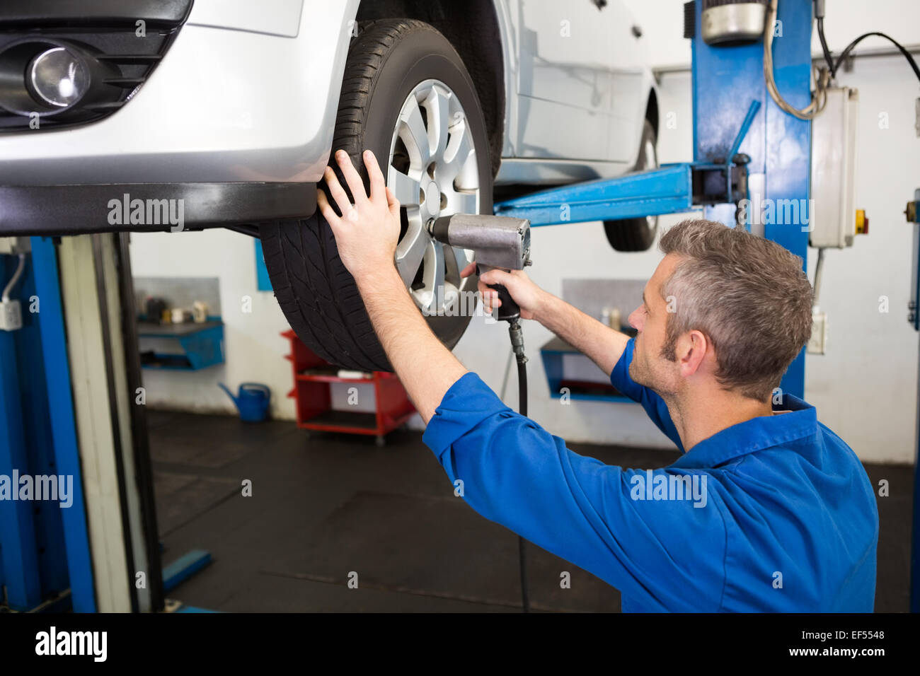 Mechanic adjusting the tire wheel Stock Photo - Alamy