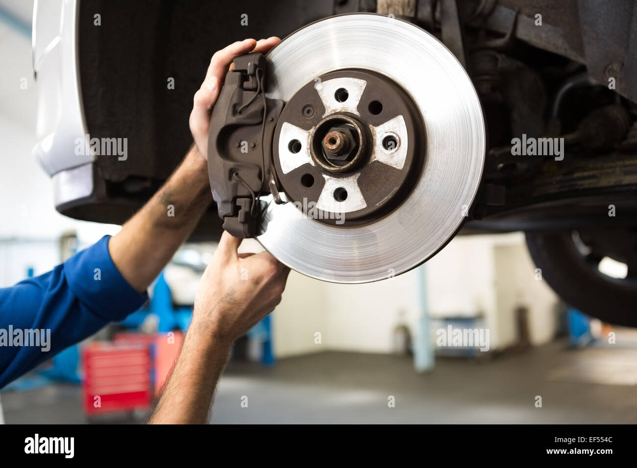 Focused mechanic adjusting the wheel Stock Photo - Alamy