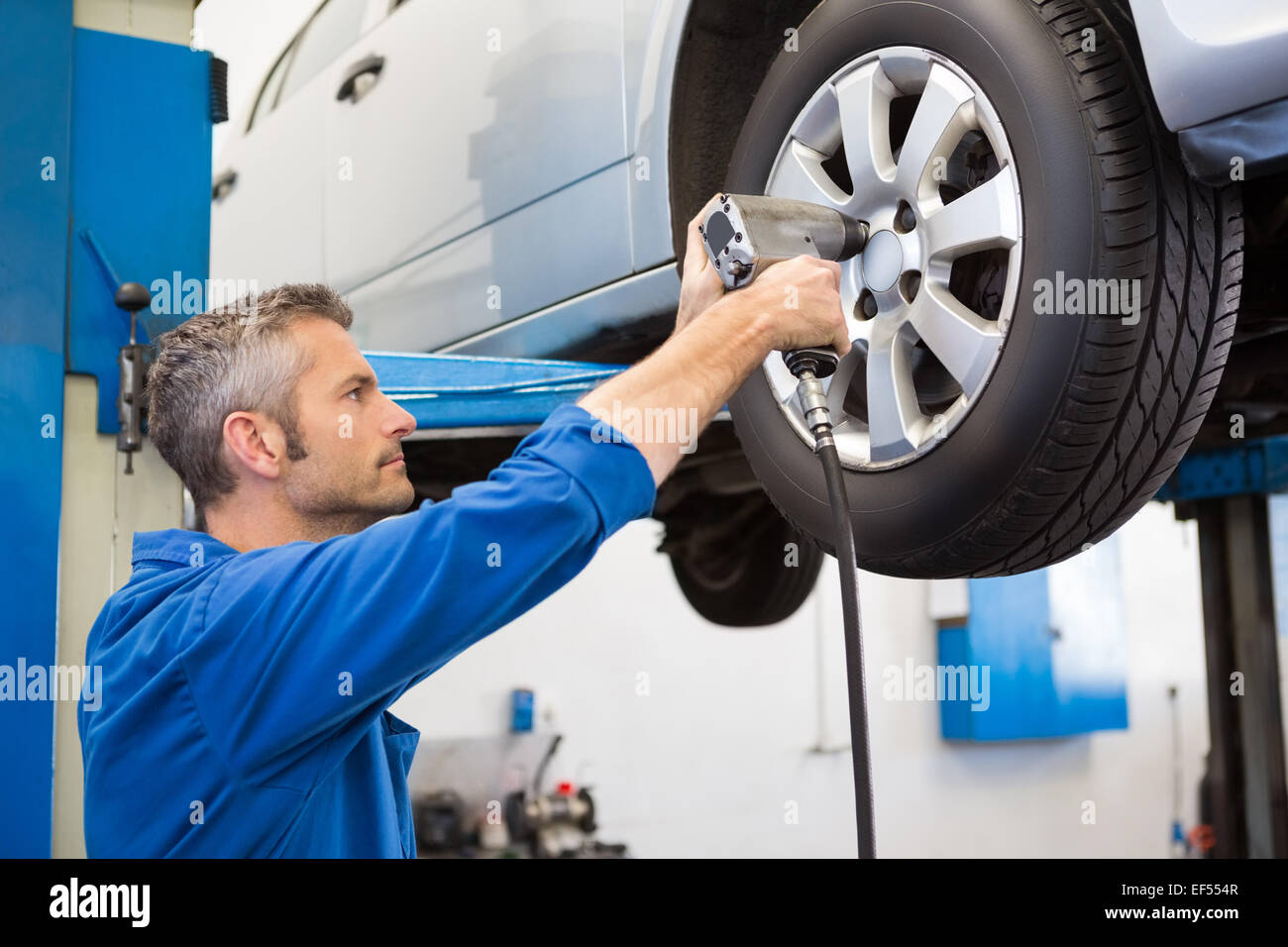 Mechanic adjusting the tire wheel Stock Photo - Alamy