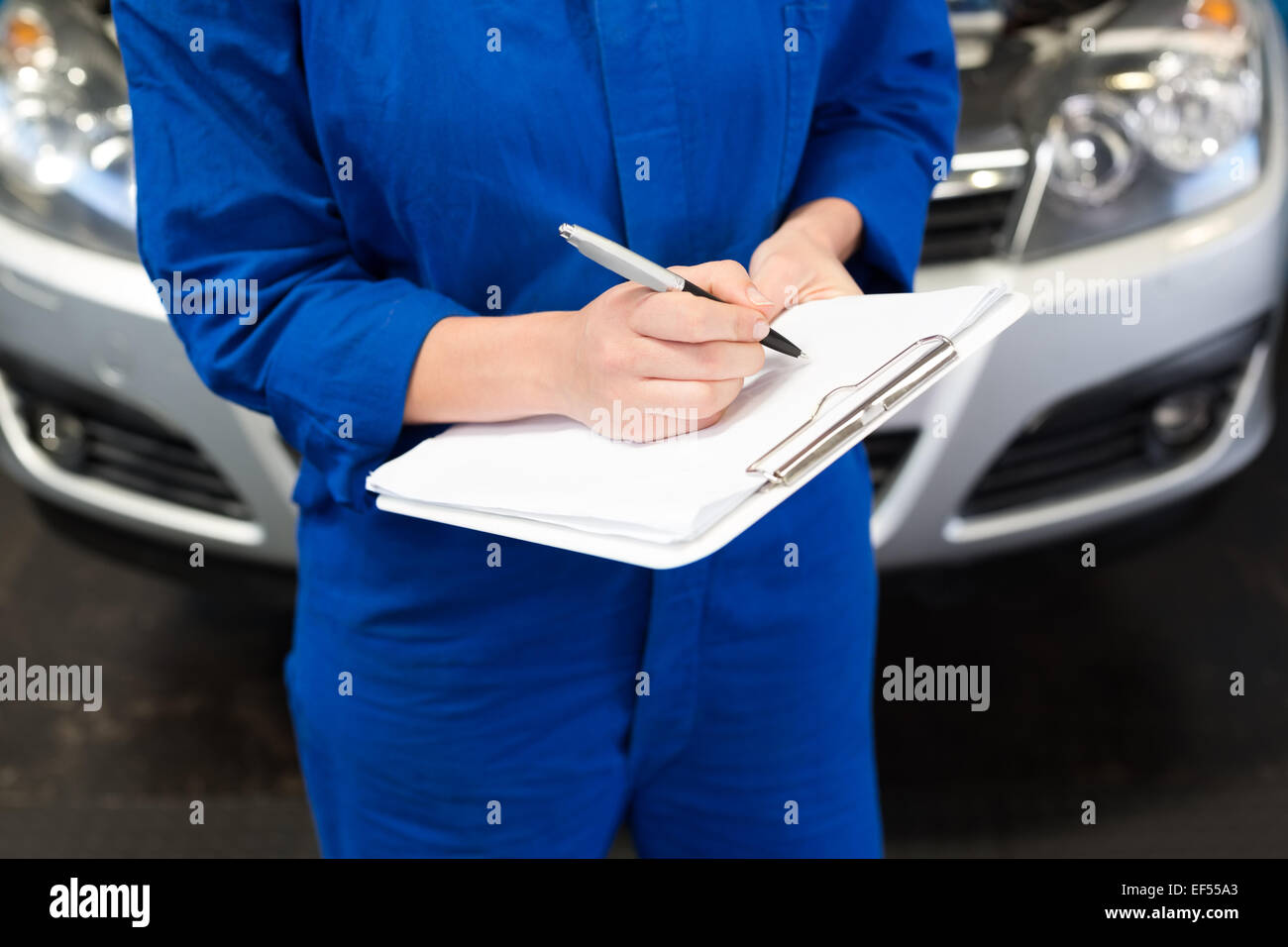 Mechanic writing on clipboard Stock Photo - Alamy