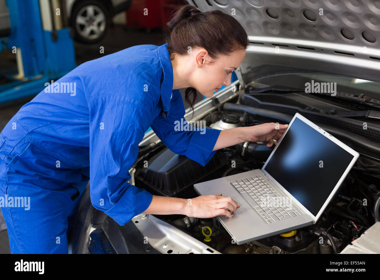 Mechanic using laptop on car Stock Photo - Alamy