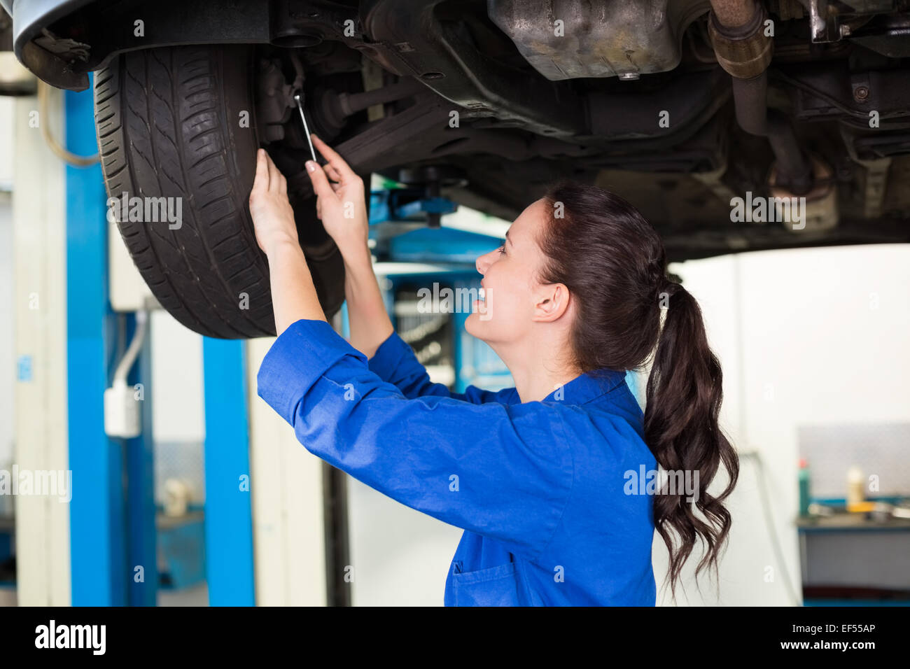 Smiling mechanic adjusting the tire Stock Photo - Alamy