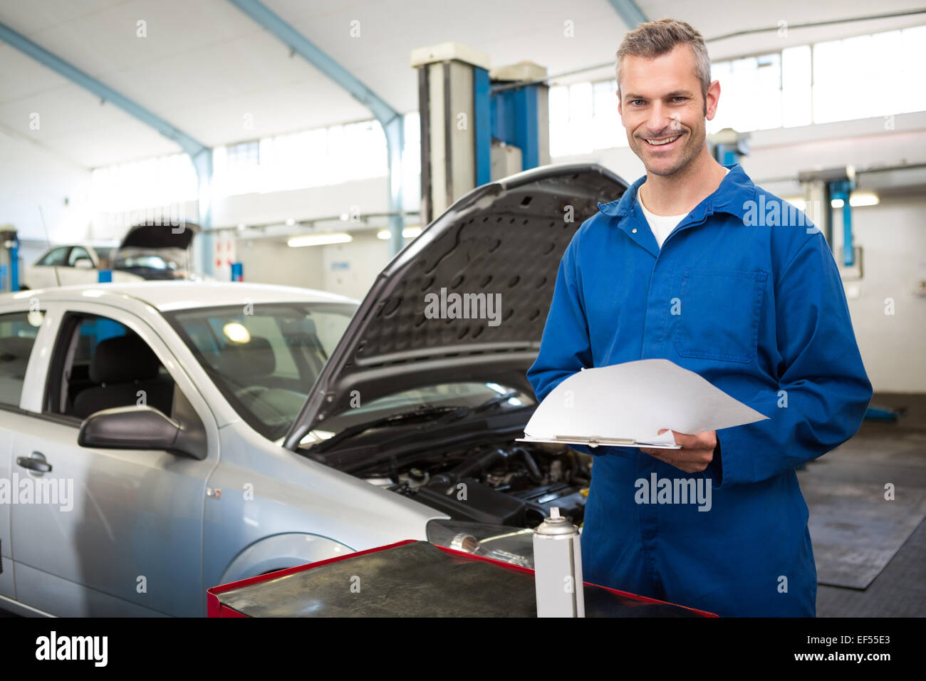 Mechanic writing on a clipboard Stock Photo - Alamy