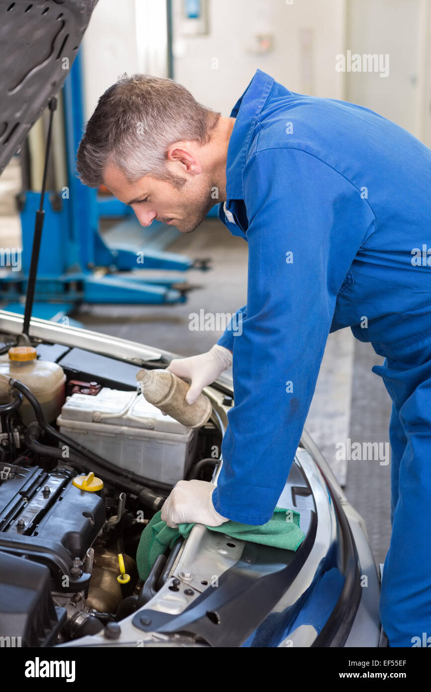 Mechanic pouring oil into car Stock Photo - Alamy