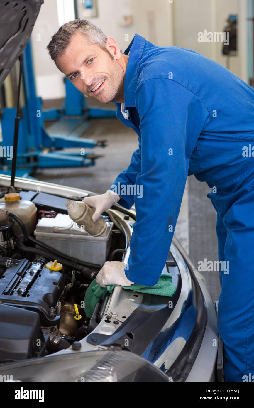 Mechanic pouring oil into car Stock Photo - Alamy