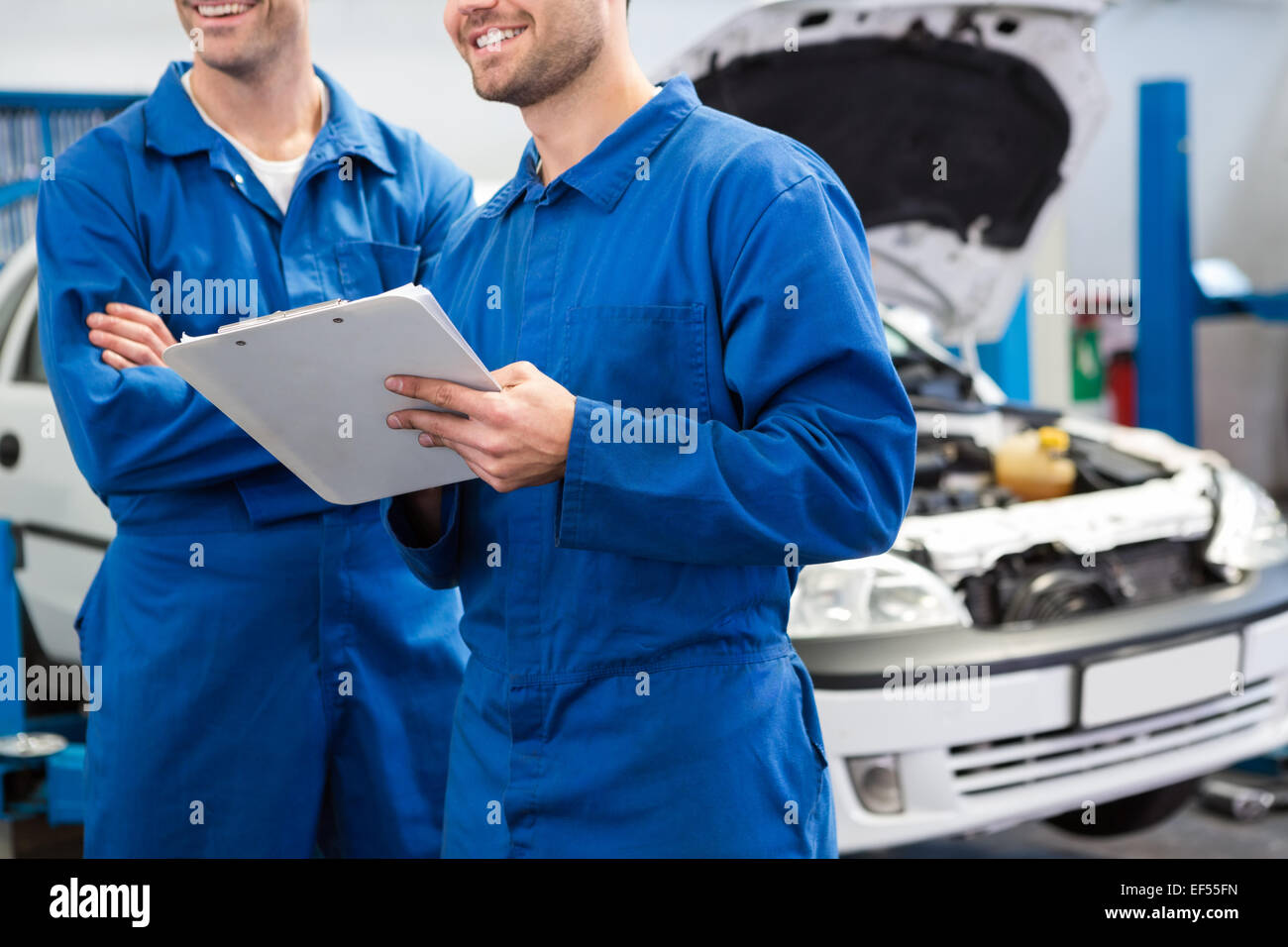 Smiling mechanic working together on clipboard Stock Photo - Alamy