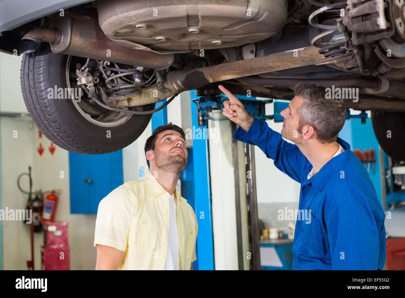 Mechanic showing customer the problem with car Stock Photo - Alamy