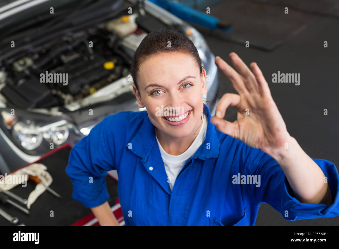 Mechanic smiling up at camera Stock Photo - Alamy