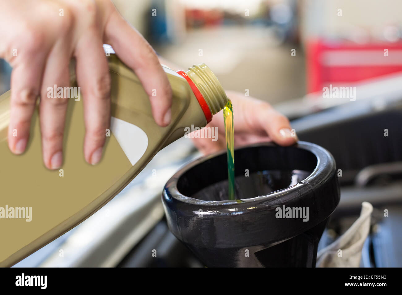 Mechanic pouring oil into car Stock Photo - Alamy