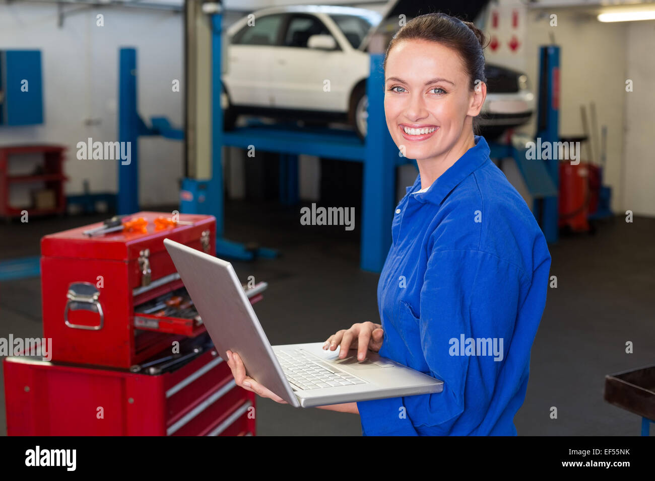 Female mechanic typing on laptop hi-res stock photography and images ...