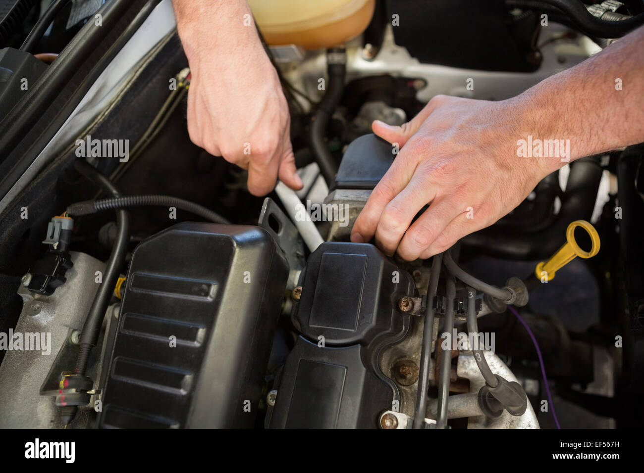 Mechanic working under the hood Stock Photo - Alamy