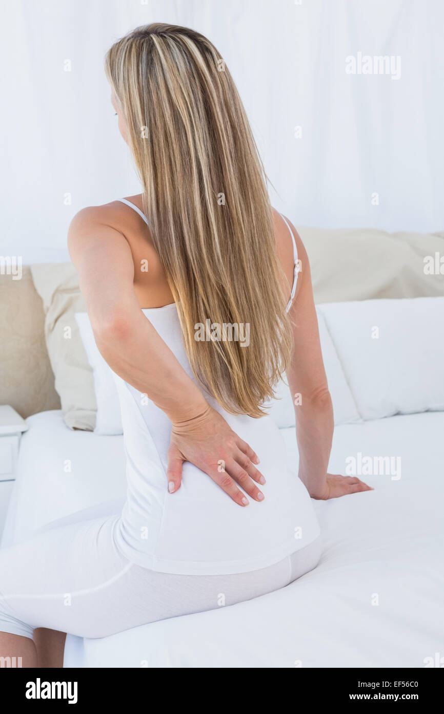 Rear view of woman getting back pain Stock Photo - Alamy