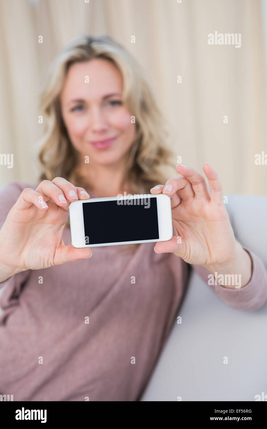 Blonde woman showing her smartphone Stock Photo - Alamy