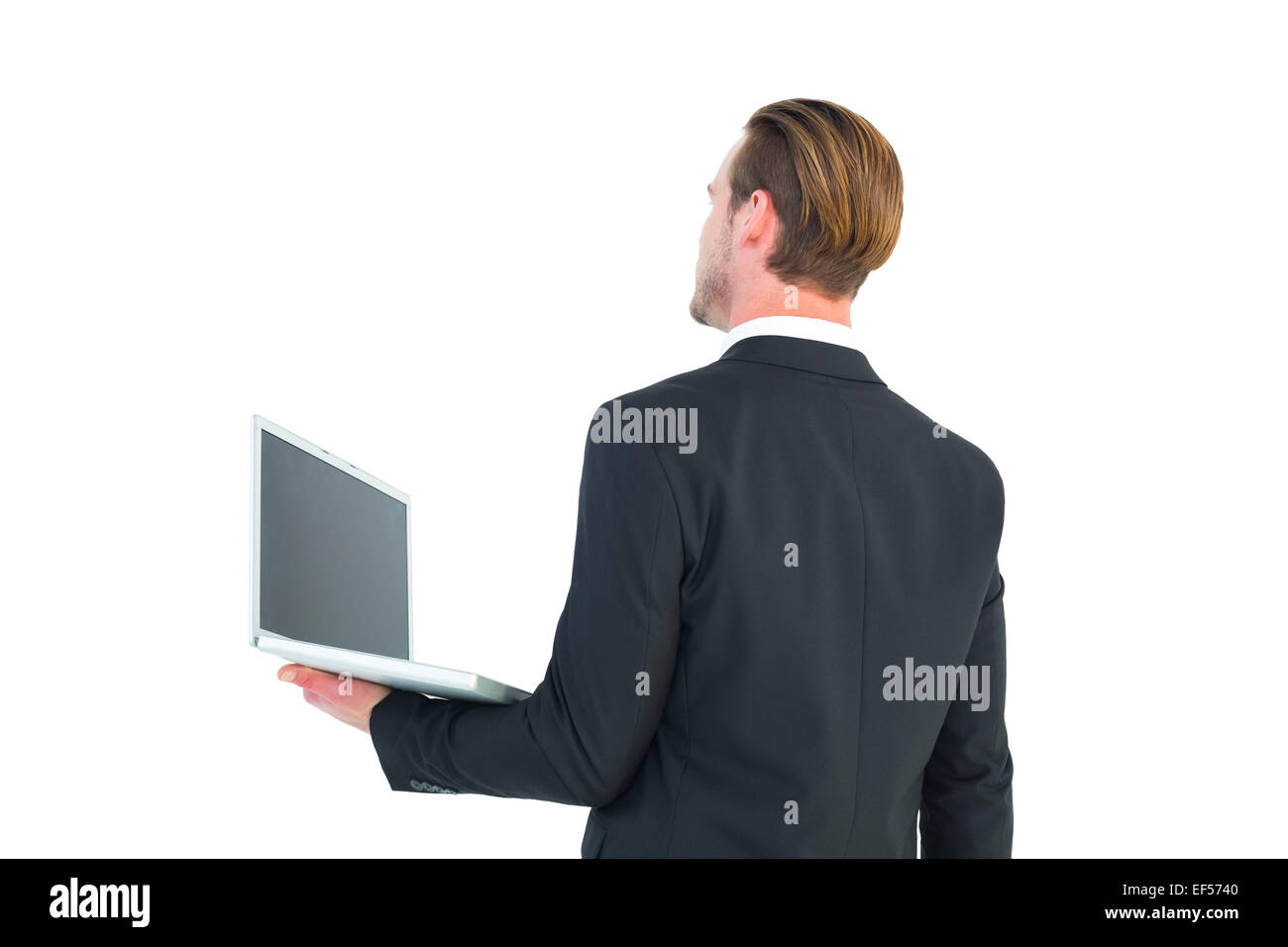 Businessman looking up holding laptop Stock Photo - Alamy