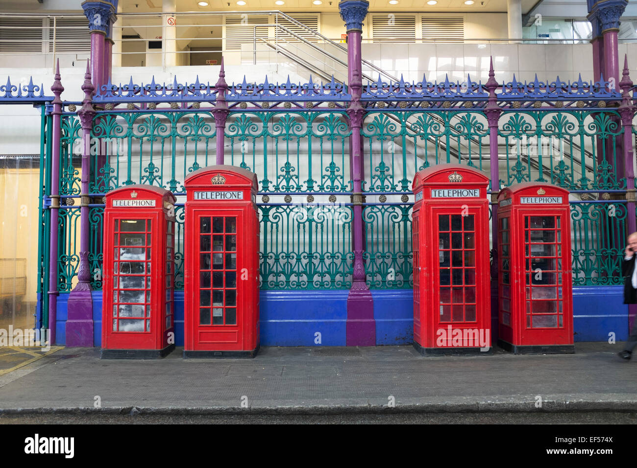 Four red telephone boxes of different sizes situated under cover in ...