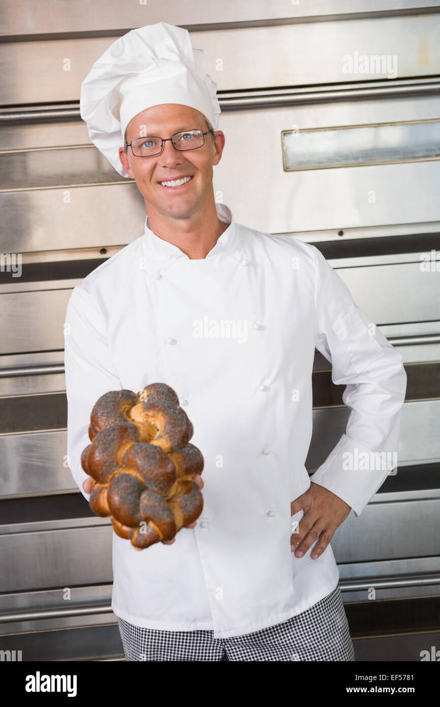 Smiling baker holding fresh loaves Stock Photo - Alamy