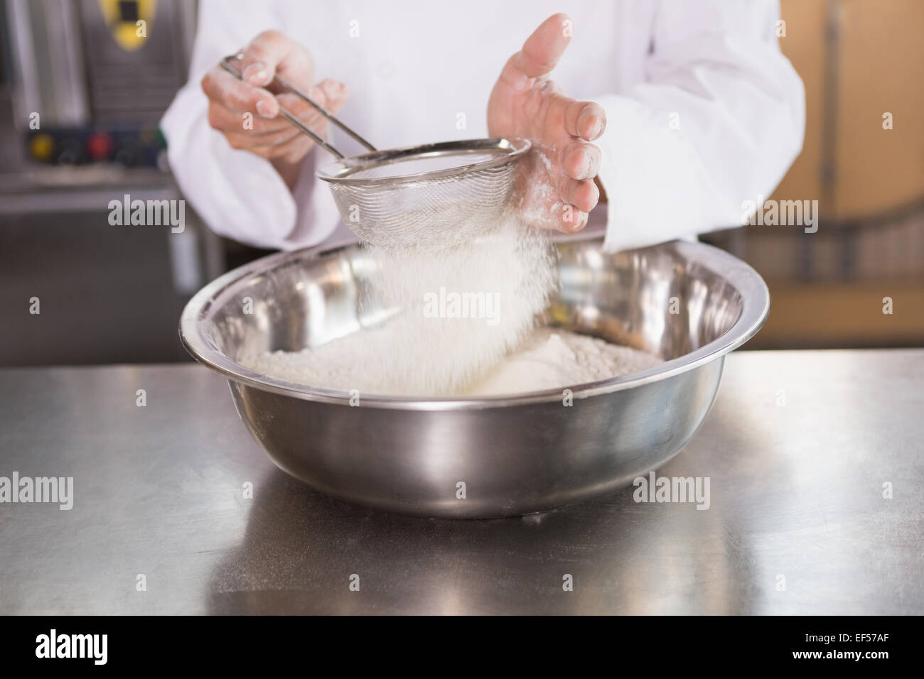 Baker sieving flour into a bowl Stock Photo - Alamy