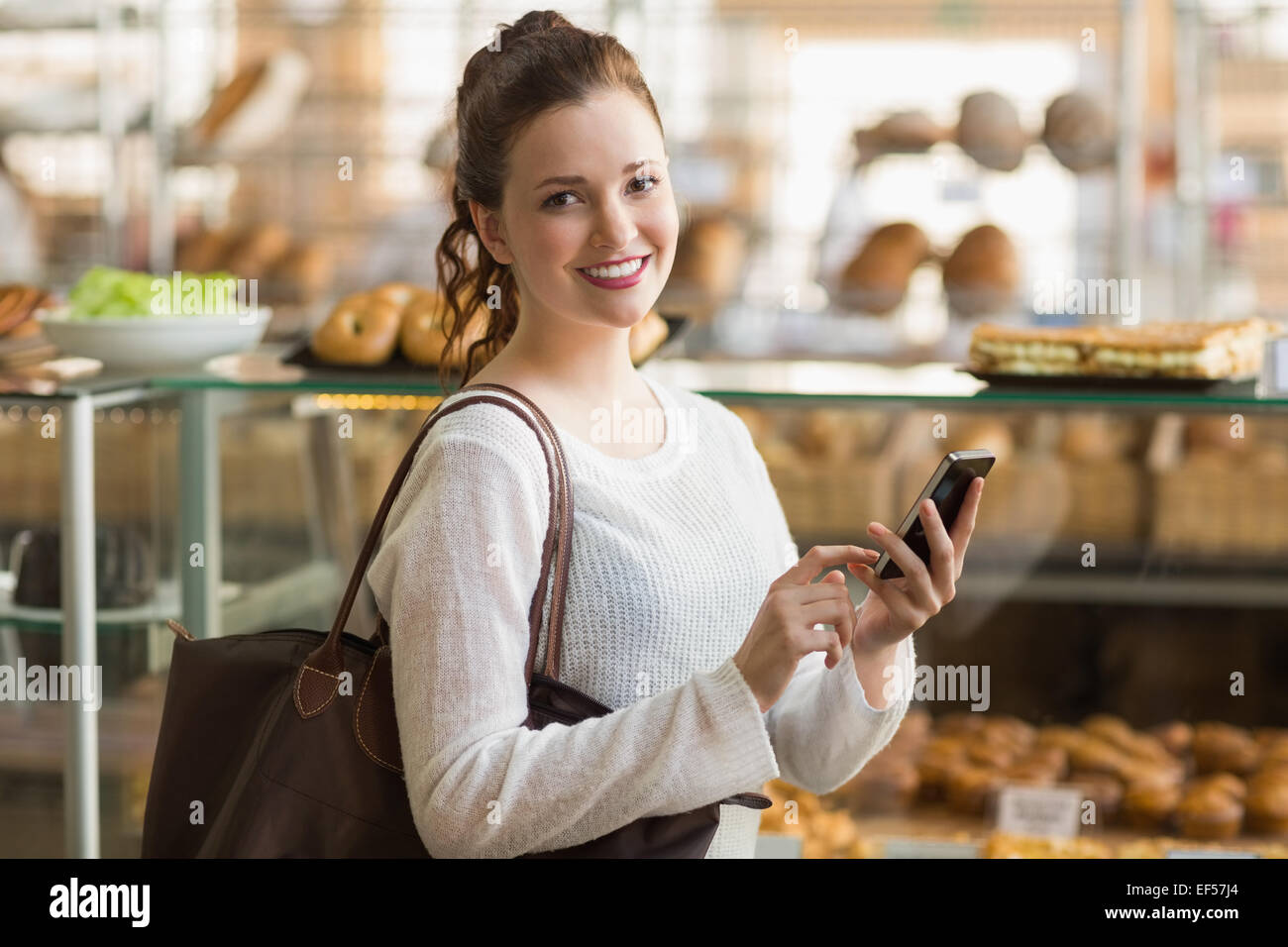 Pretty brunette sending a text Stock Photo - Alamy