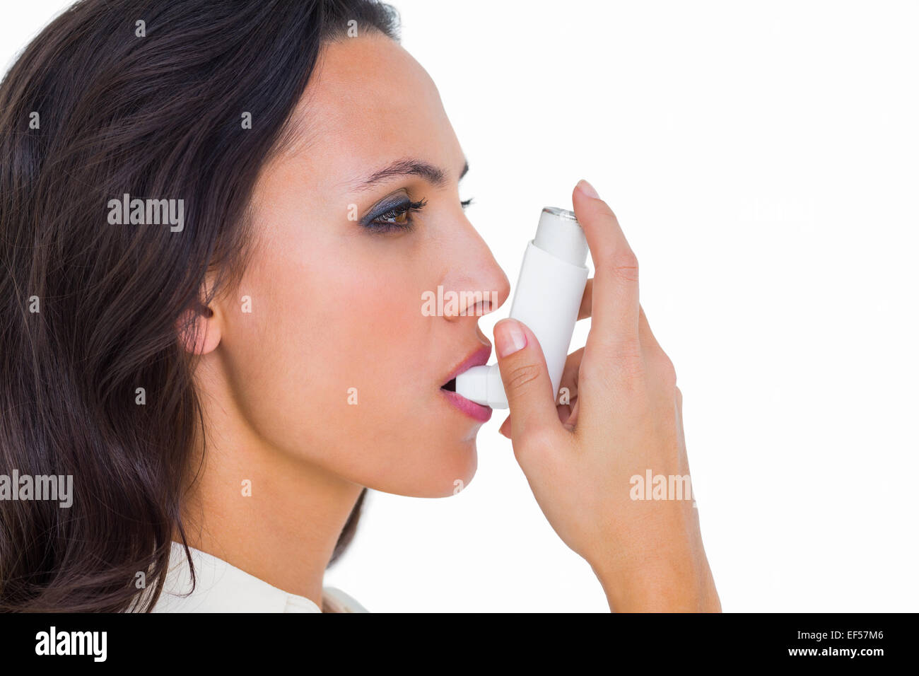 Asthmatic brunette using her inhaler Stock Photo - Alamy