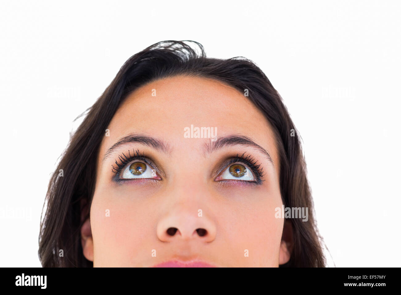 Pretty brunette looking up thoughfully Stock Photo - Alamy