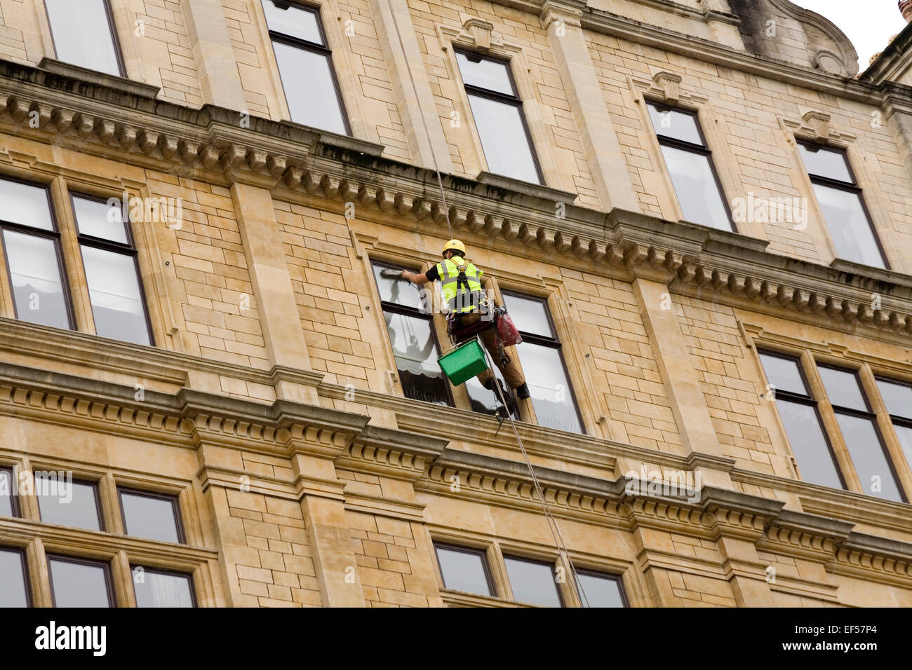 Anonymous window cleaner hanging on the outside of multi-storey ...