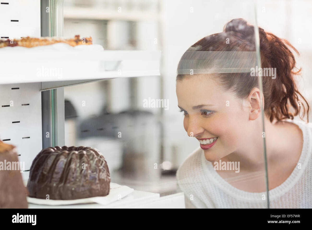 Pretty brunette looking at cake Stock Photo - Alamy