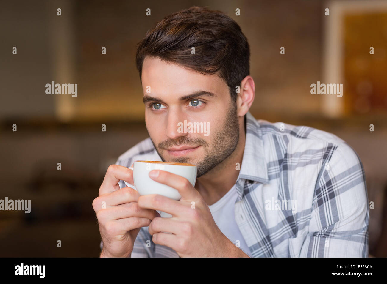 Young man having cup of coffee Stock Photo - Alamy