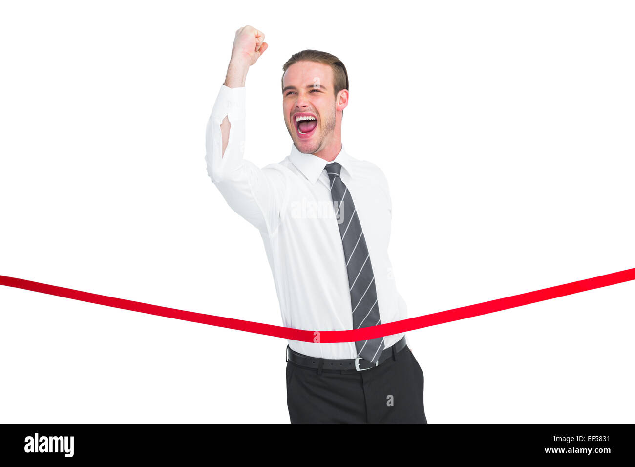 Businessman crossing the finish line while clenching fist Stock Photo ...