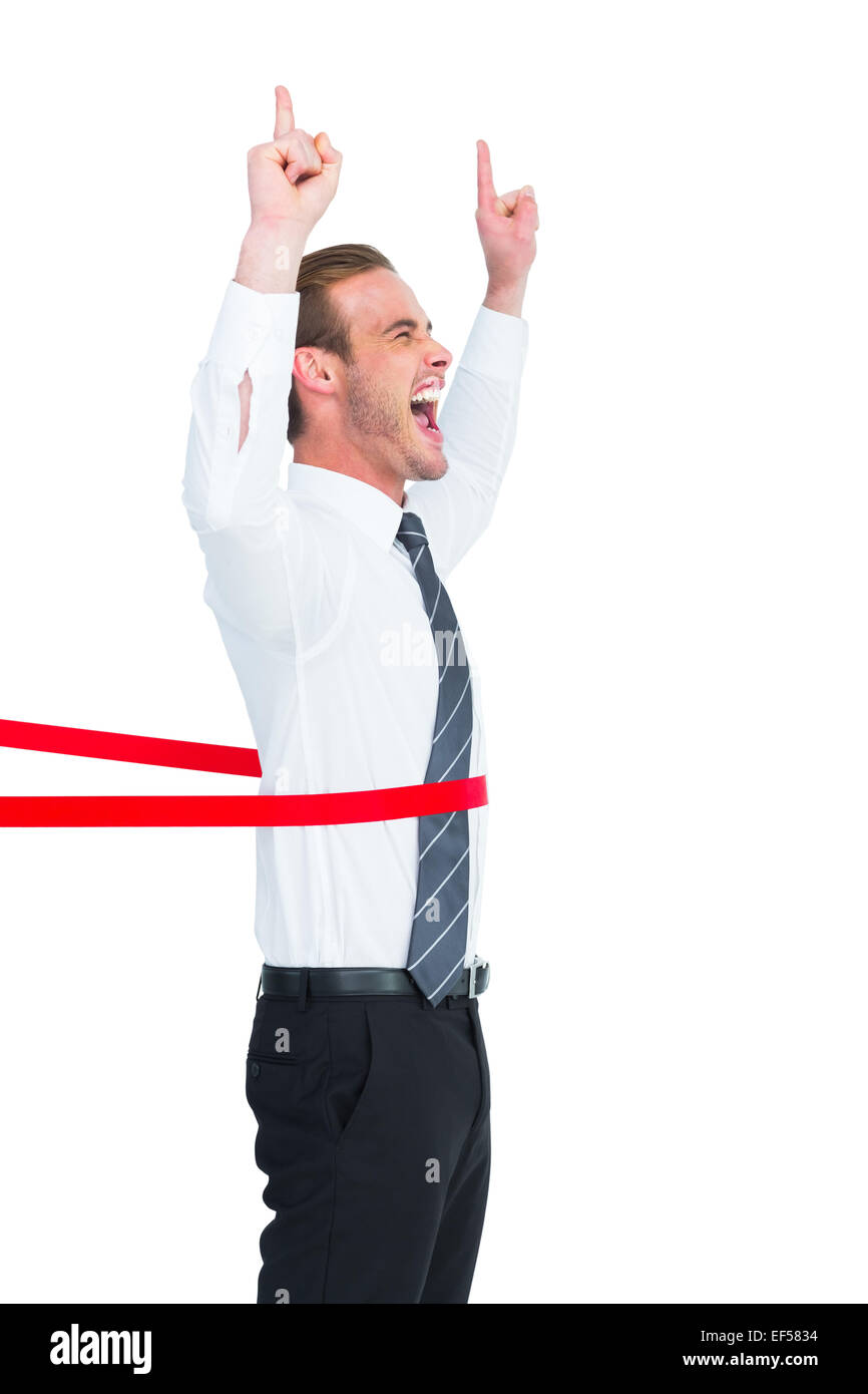 Happy businessman crossing the finish line and pointing up Stock Photo ...