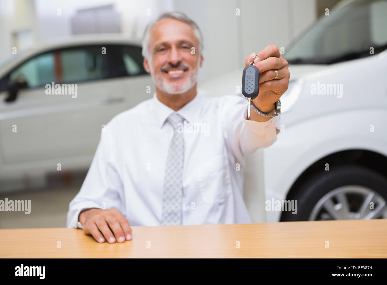Smiling salesman giving a customer car keys Stock Photo - Alamy