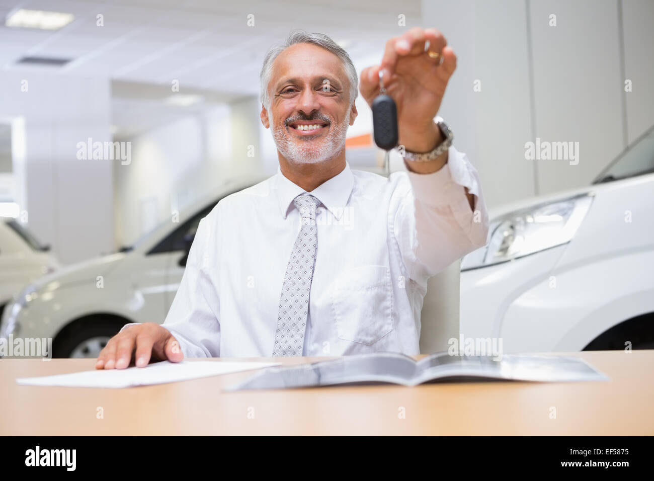 Smiling salesman giving a customer car keys Stock Photo - Alamy