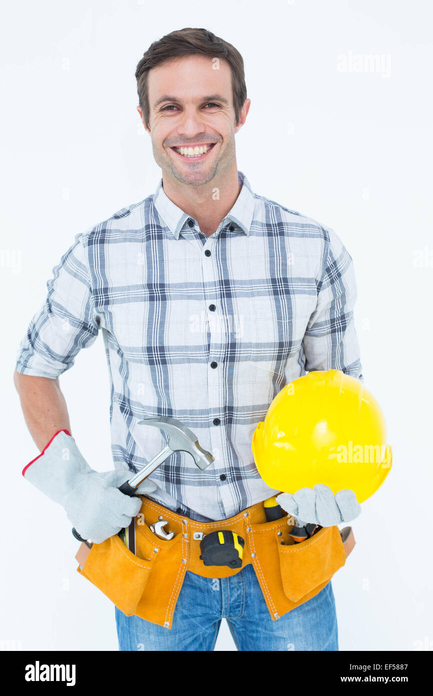 Happy handyman holding hammer and hard hat Stock Photo - Alamy