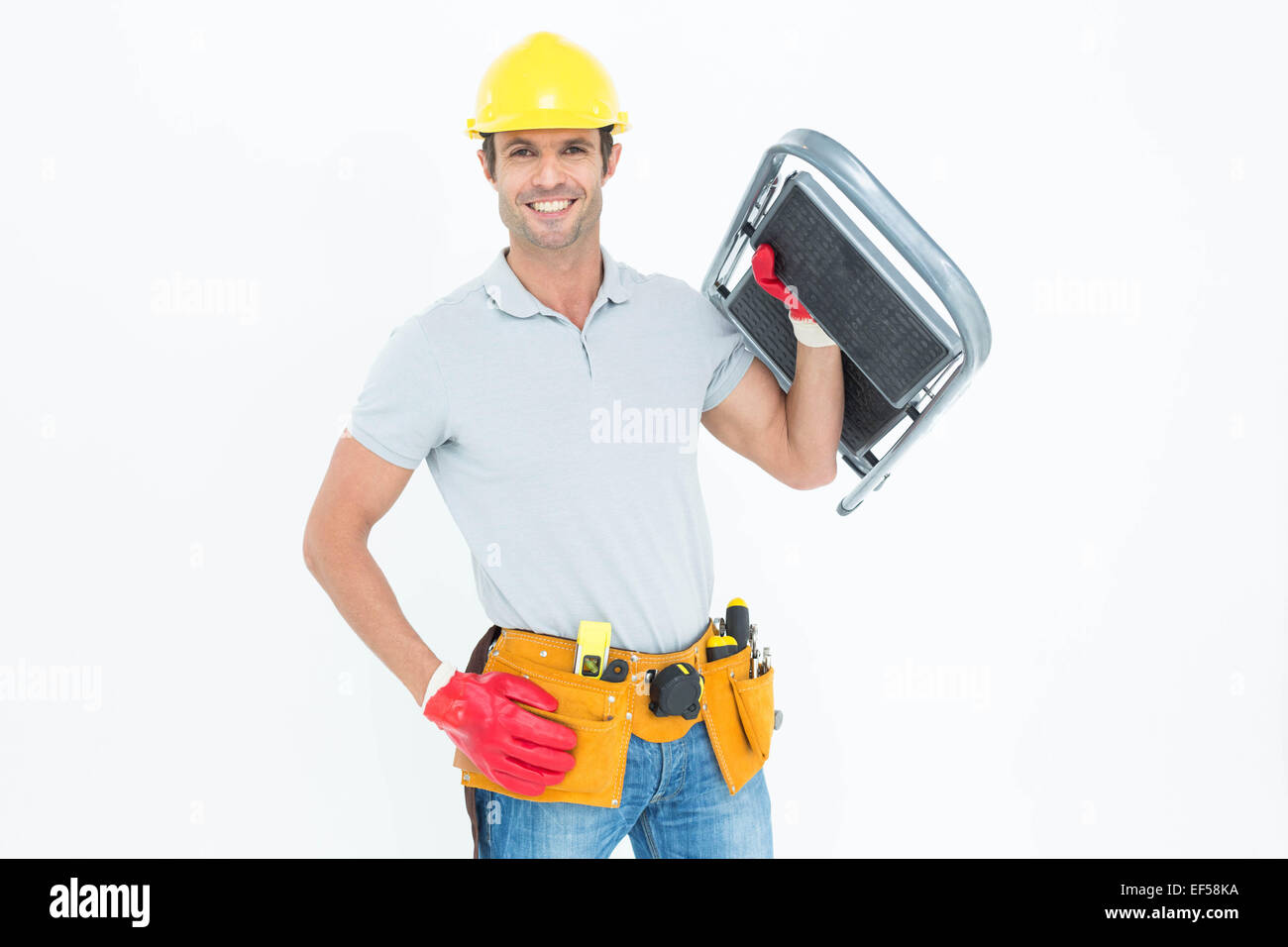 Confident worker carrying step ladder Stock Photo - Alamy