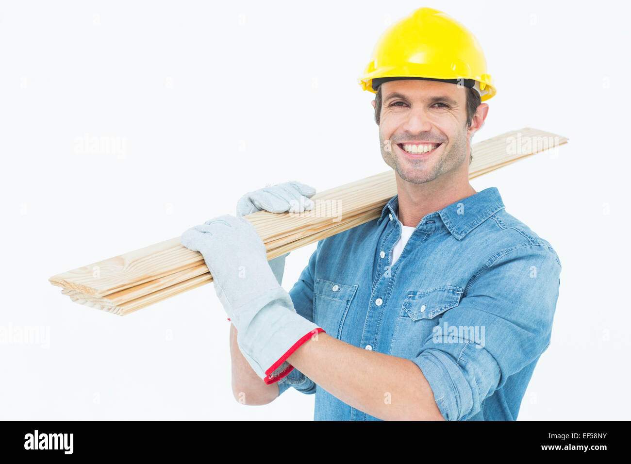 Happy carpenter carrying wooden planks Stock Photo - Alamy
