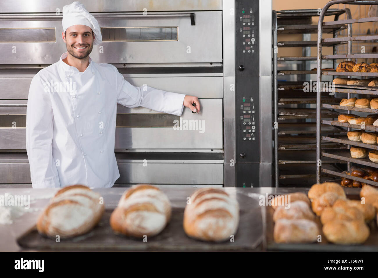 Happy baker leaning on professional oven Stock Photo - Alamy