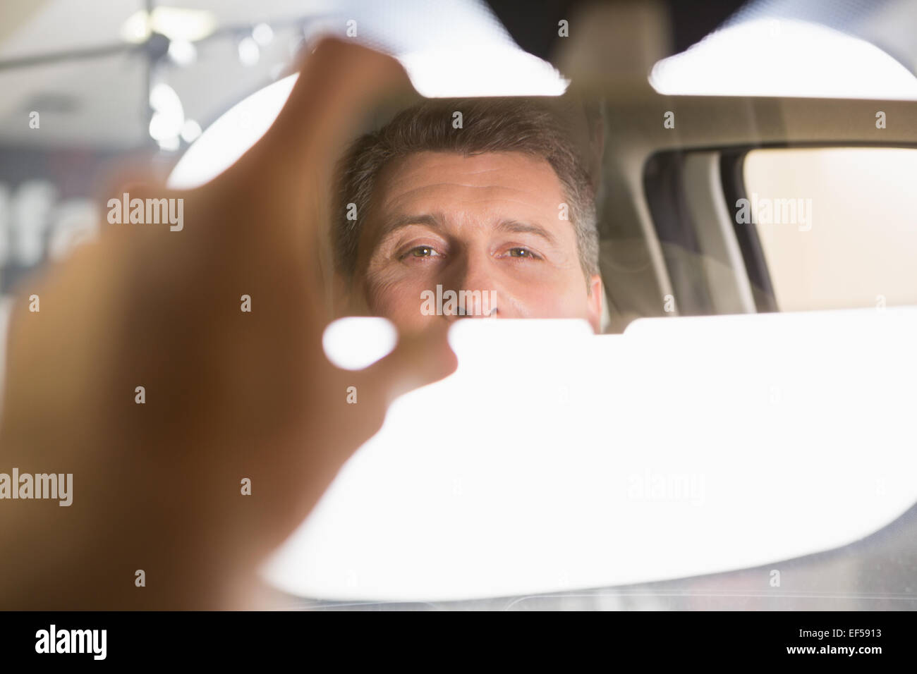 Man looking in an interior car mirror Stock Photo - Alamy