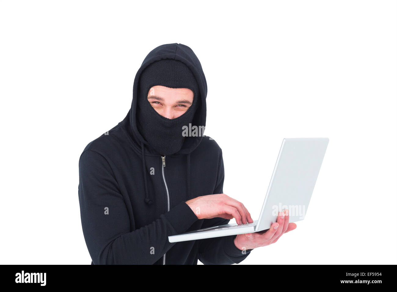 Hacker in balaclava using laptop to steal identity Stock Photo - Alamy
