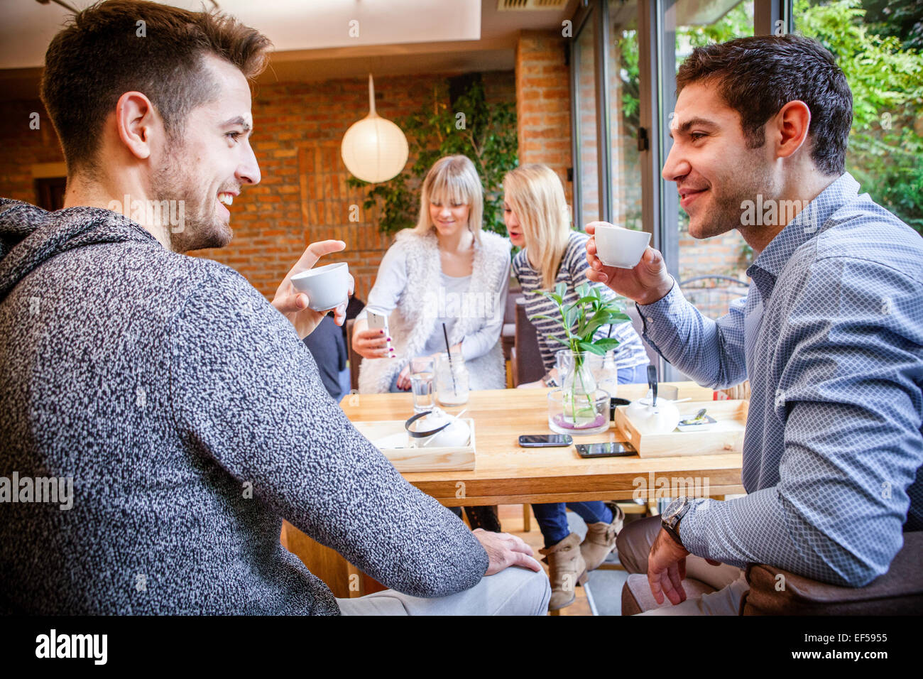 Friends having coffee together at home Stock Photo - Alamy
