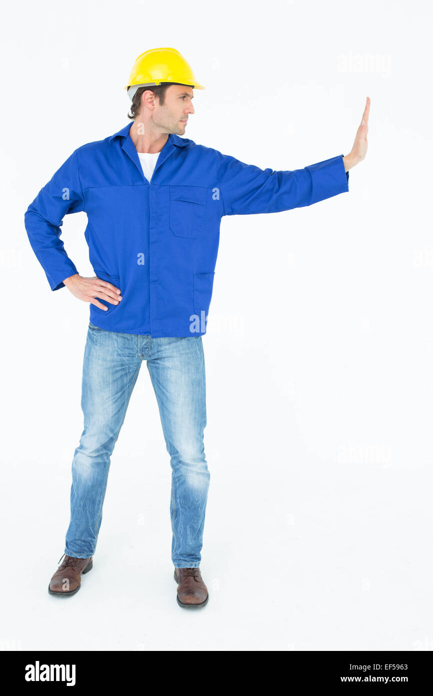 Confident architect pushing over white background Stock Photo - Alamy