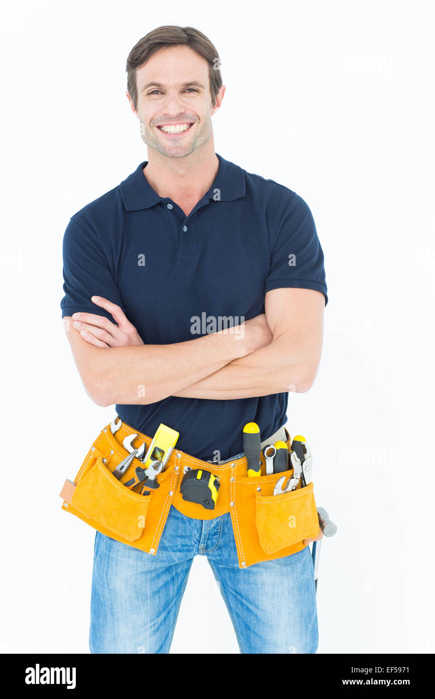 Confident man with tool belt around waist over white background Stock ...