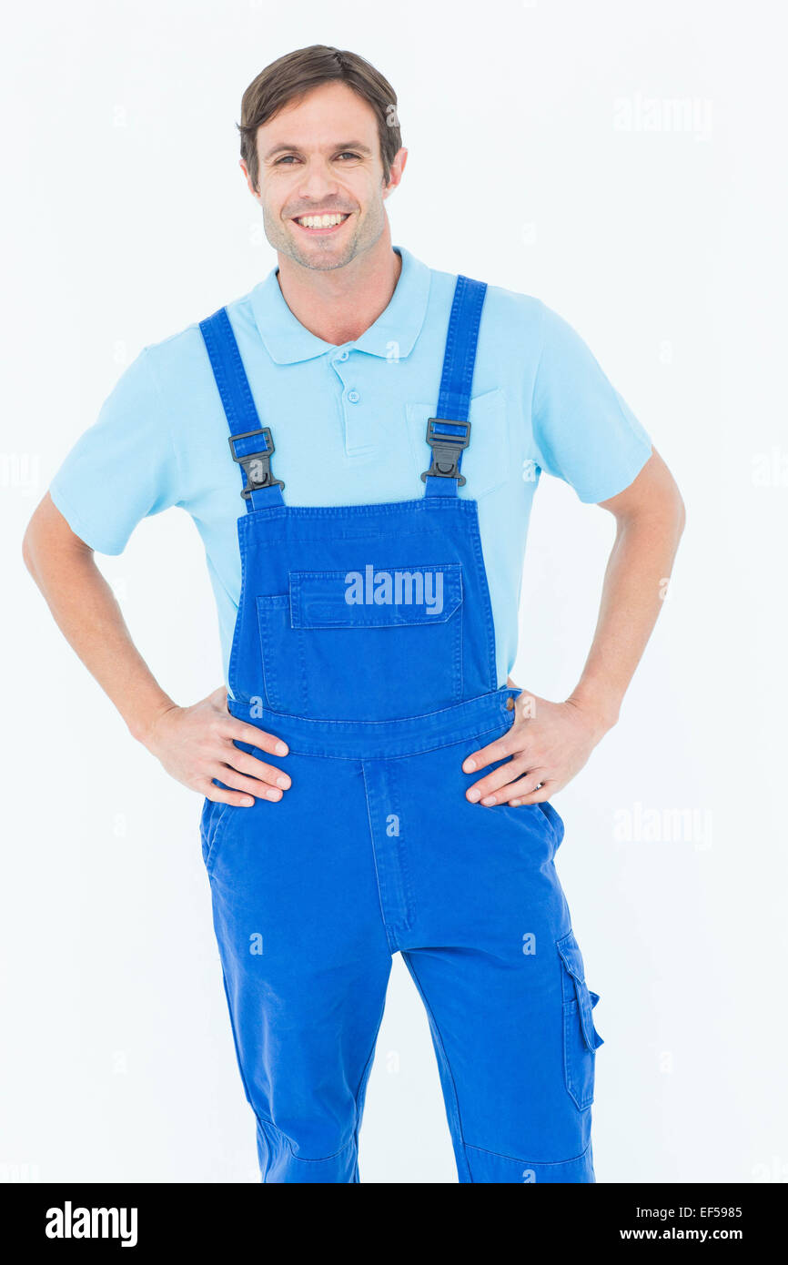 Happy carpenter in overalls with hands on hip Stock Photo - Alamy