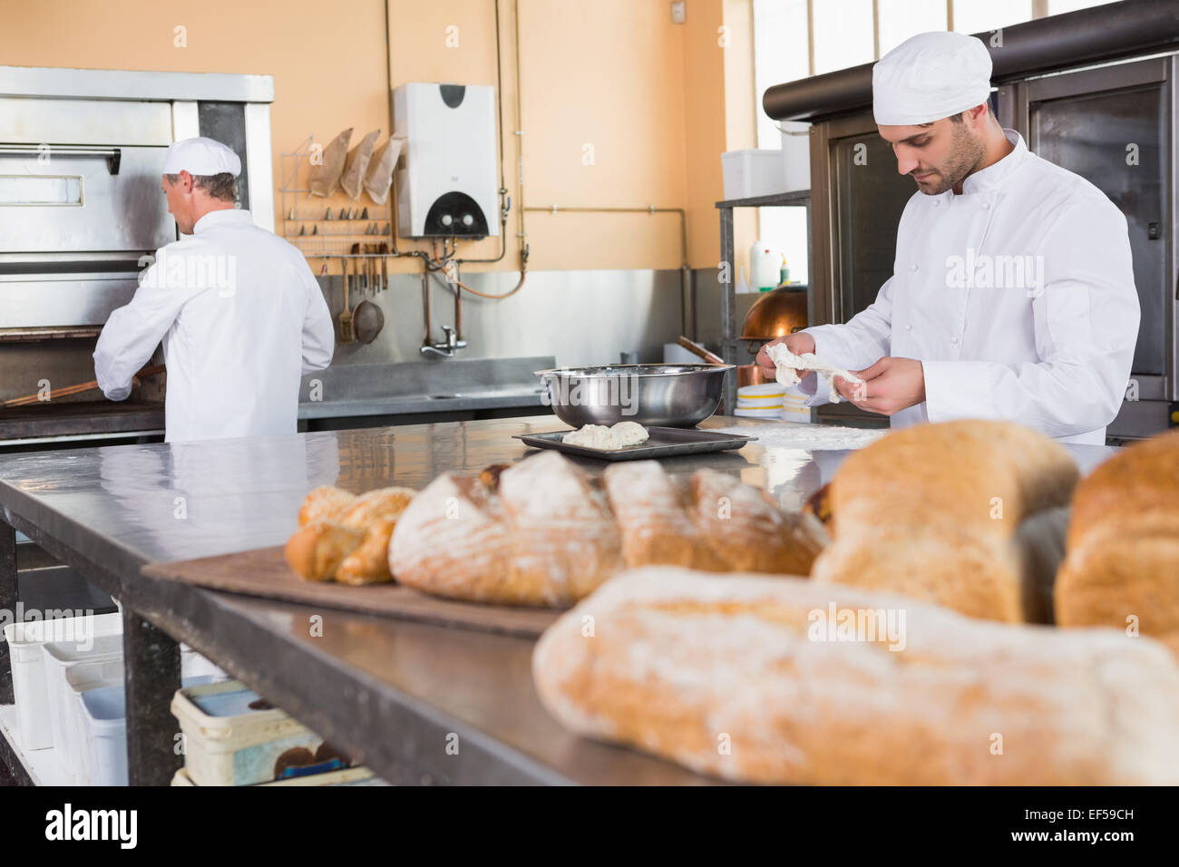 Baker making dough in mixing bowl Stock Photo - Alamy