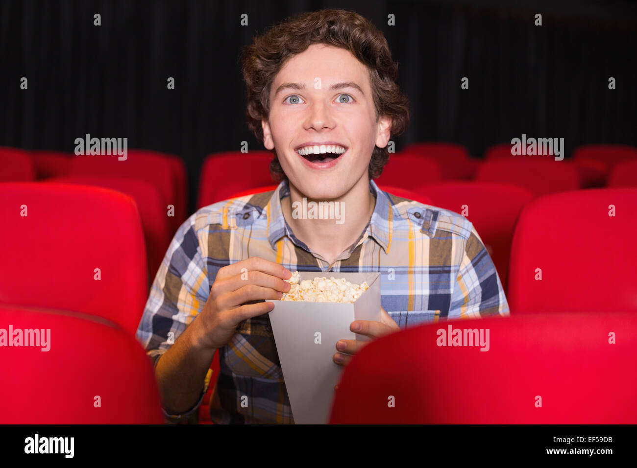 Young man watching a film Stock Photo - Alamy