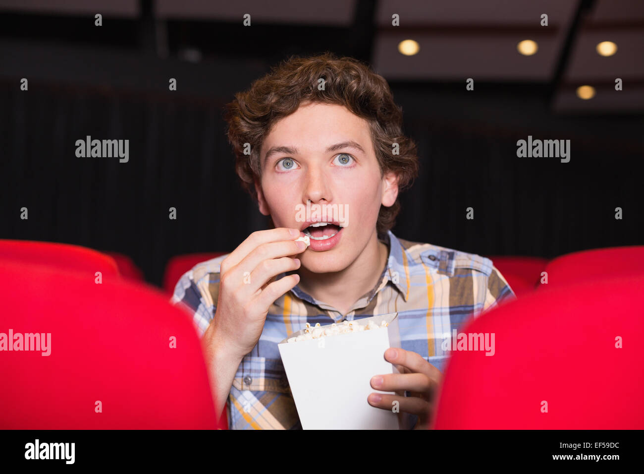 Young man watching a film Stock Photo - Alamy
