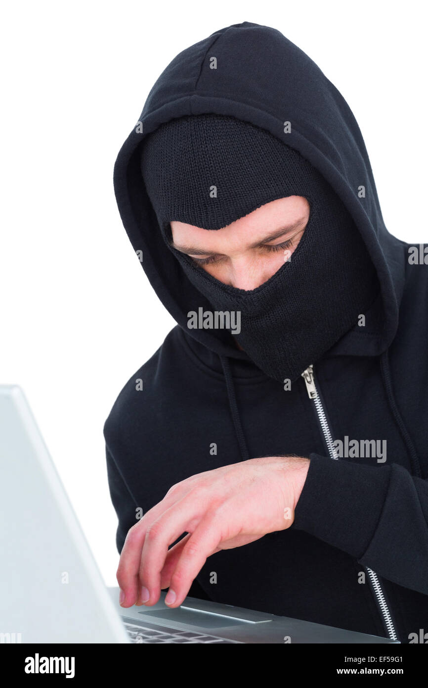 Hacker in balaclava typing on laptop Stock Photo - Alamy