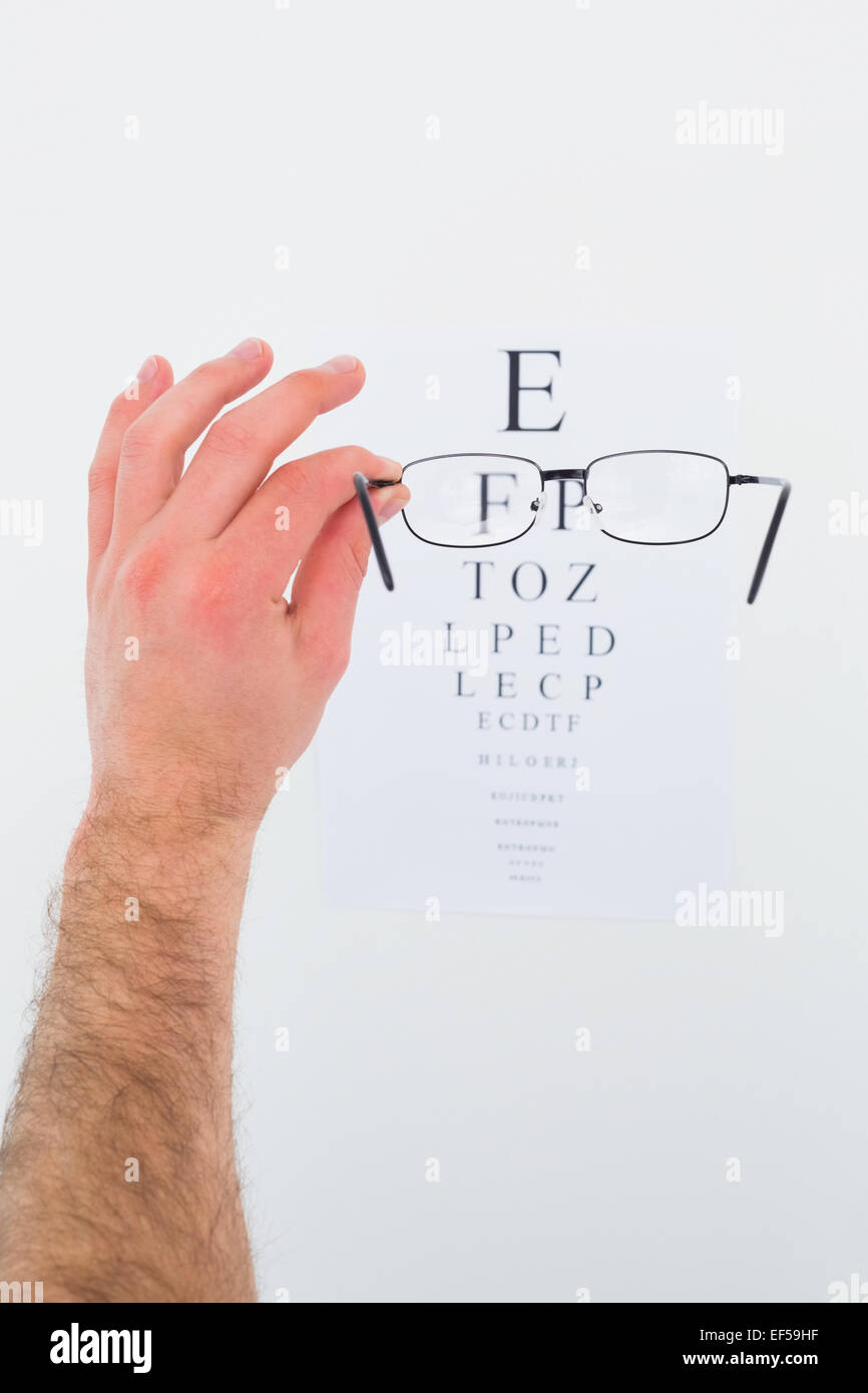 Hand holding glasses for a eye test Stock Photo - Alamy