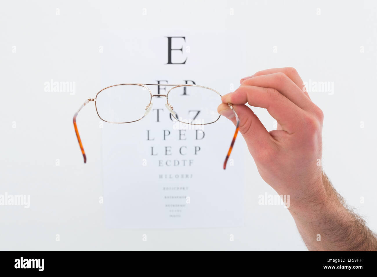 Hand holding glasses for a eye test Stock Photo - Alamy
