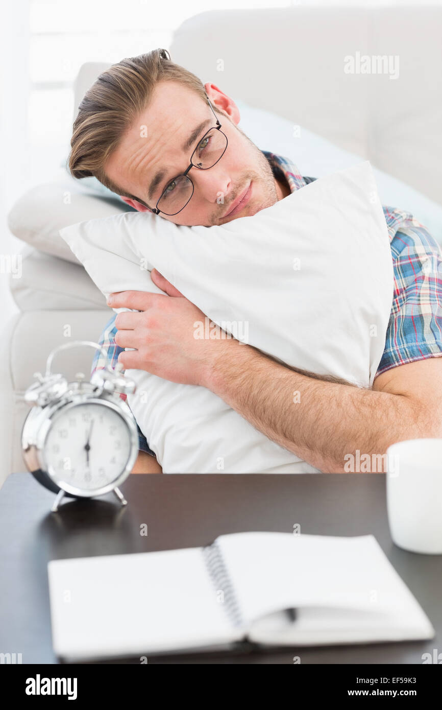 Bored man beside alarm clock Stock Photo - Alamy