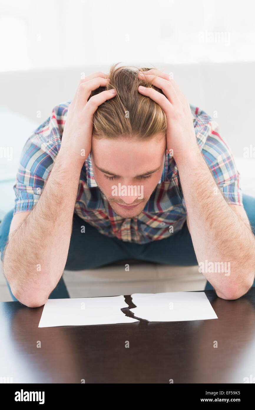 Sad man with hands on his head looking ripped paper Stock Photo - Alamy