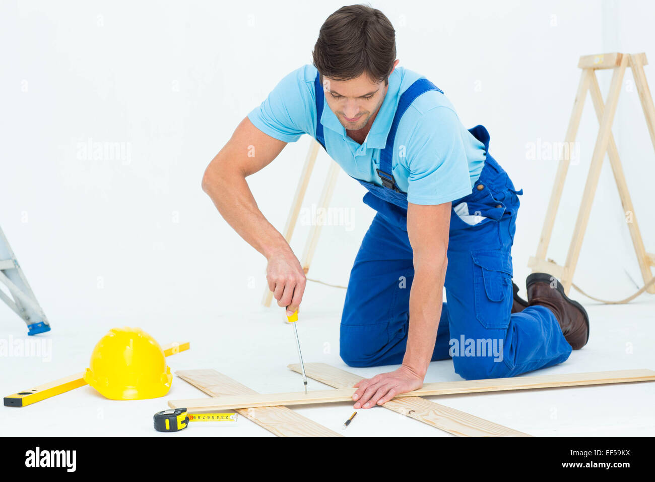 Repairman fixing screw on plank Stock Photo - Alamy